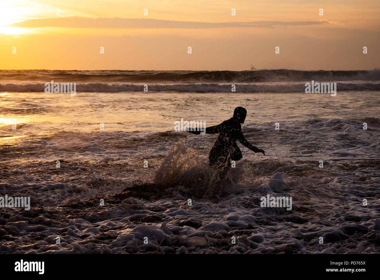 Man running into waves hi-res stock photography and images - Alamy