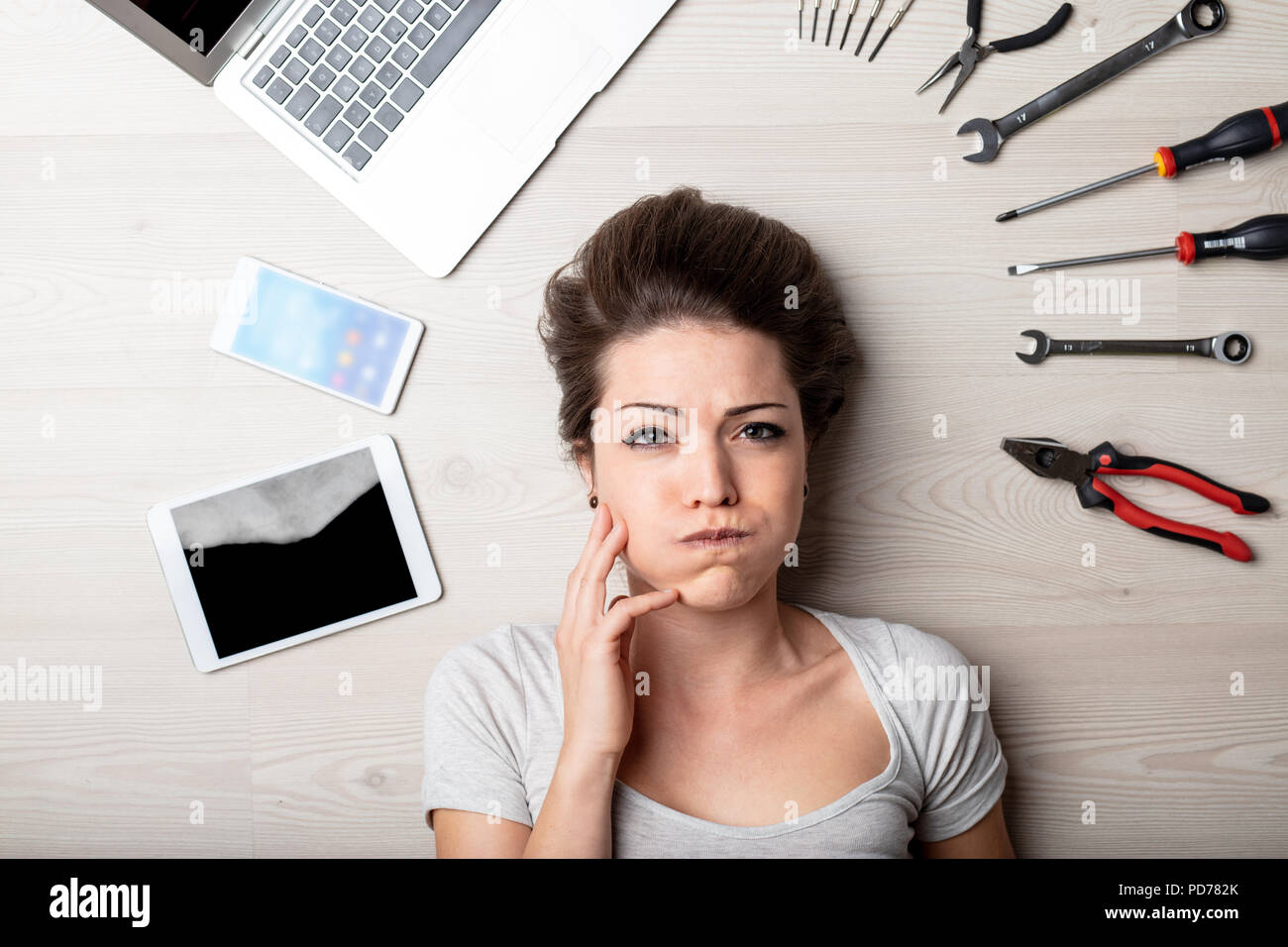 Exasperated woman blowing out her cheeks as she lies on the floor in a ...
