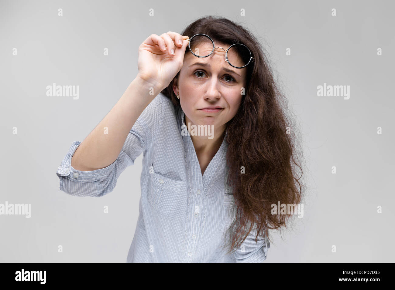 Young brunette girl with glasses. She raised her glasses Stock Photo ...