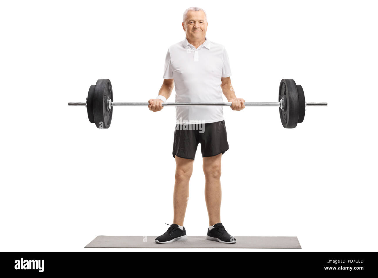 Full length portrait of a senior standing on an exercise mat and ...