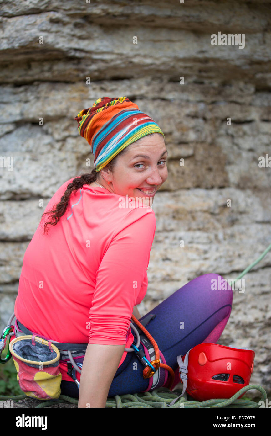 Photo from back of smiling woman climbing woman sitting next to ...