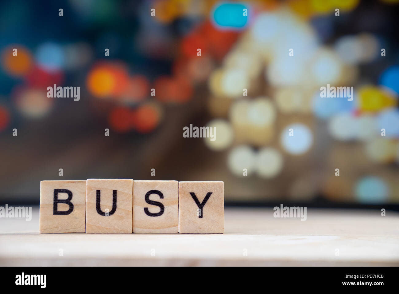 busy word Written In Wooden Cube on wood table with traffic bokeh in ...