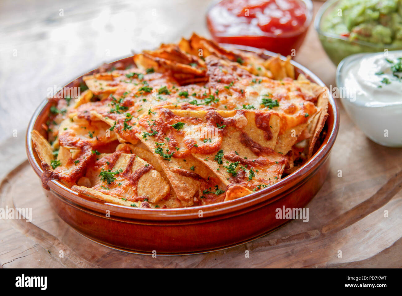 baked nacho chips with cheese and dips Stock Photo - Alamy