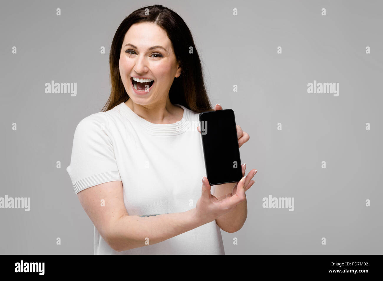 Young woman presenting telephone Stock Photo - Alamy