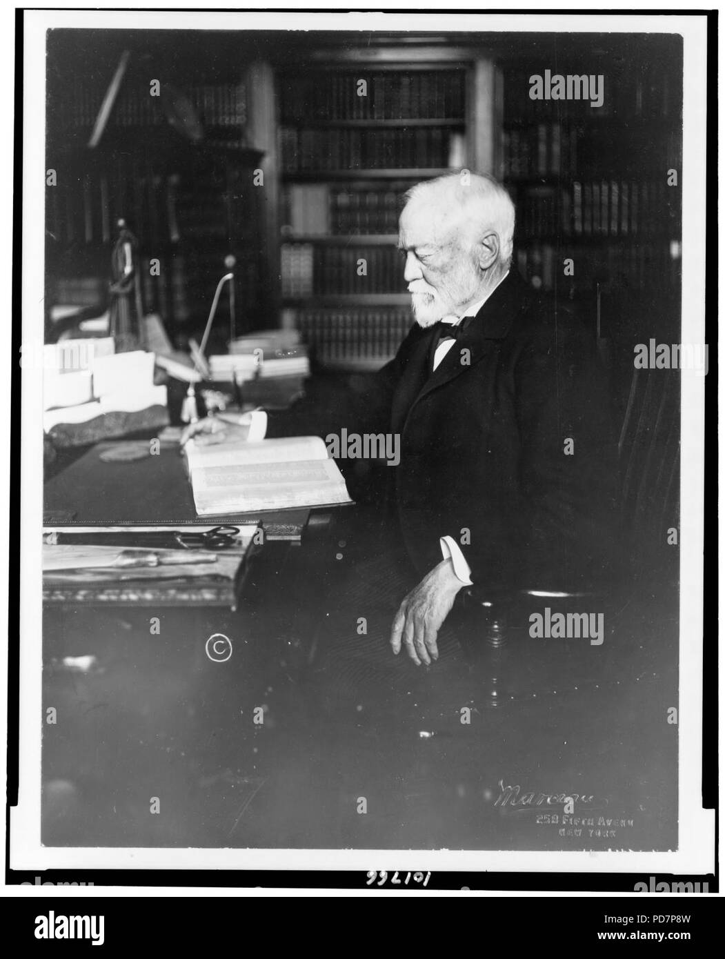 Andrew Carnegie, three-quarter length portrait, seated at desk, reading ...