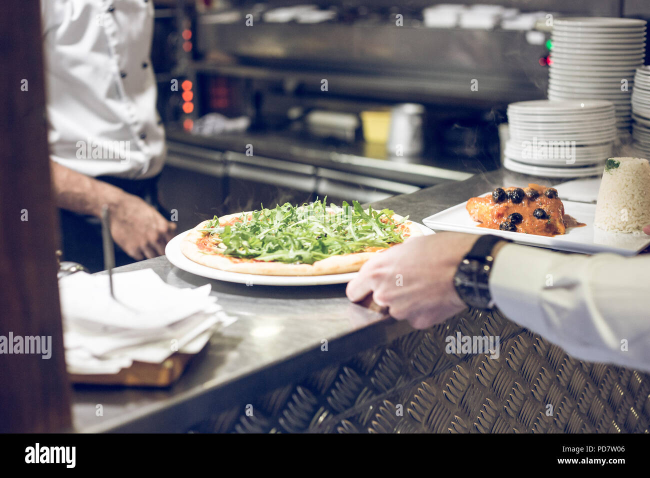 Chef preparing serving food in Italian restaurant kitchen Stock Photo ...