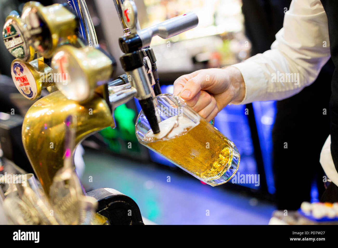 Bartender pouring a beer for a customer in a nightclub bar Stock Photo ...