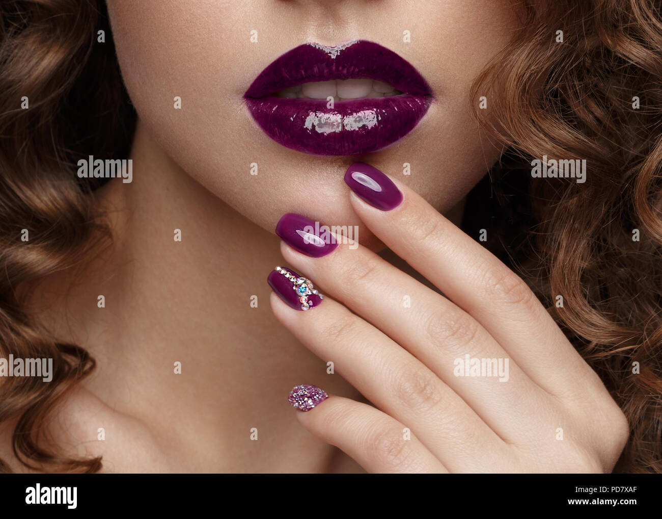 Beautiful girl with evening make-up, purple lips, curls and design ...