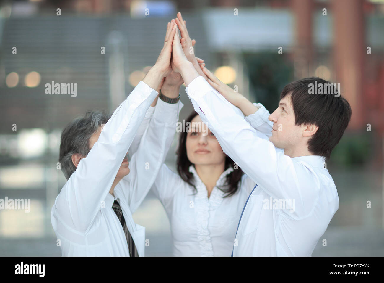 members of the business team giving each other a high-five,standing in ...