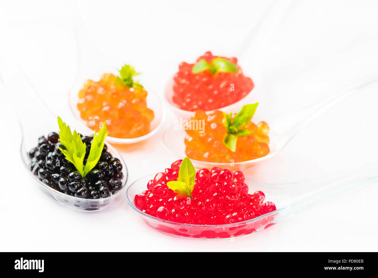 Plastic spoons with fish caviar on a white background Stock Photo - Alamy