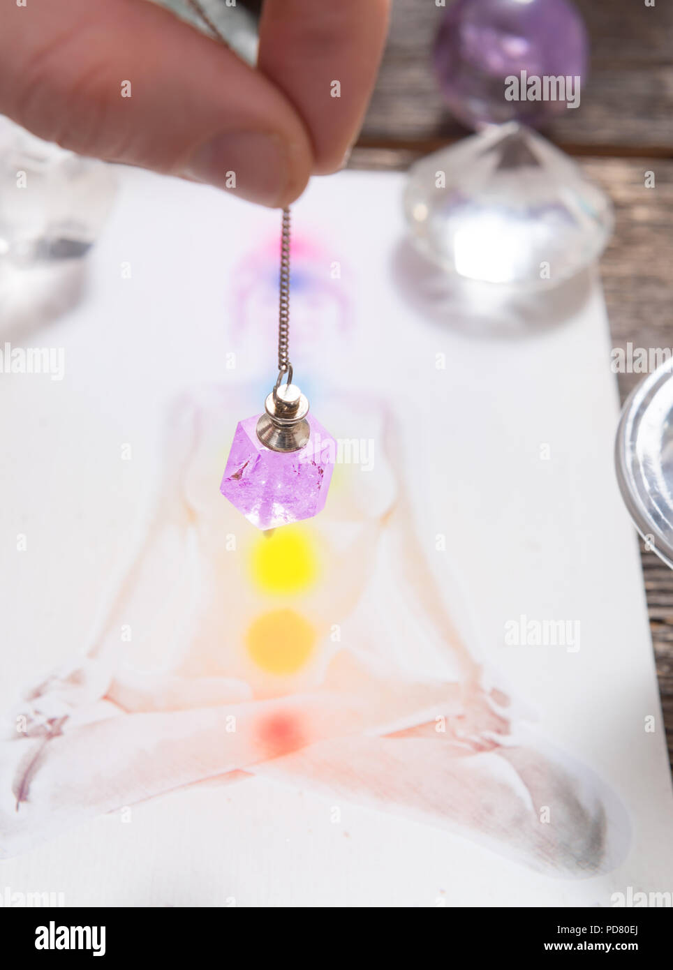 Chakras illustrated over human body with natural crystals and pendulum ...
