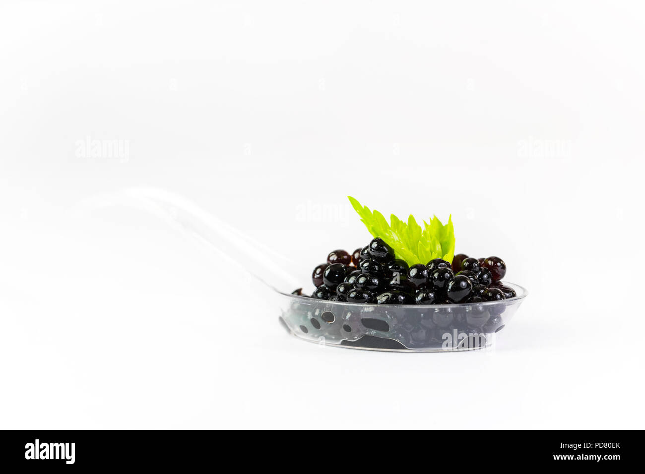 Plastic spoons with fish caviar on a white background Stock Photo - Alamy