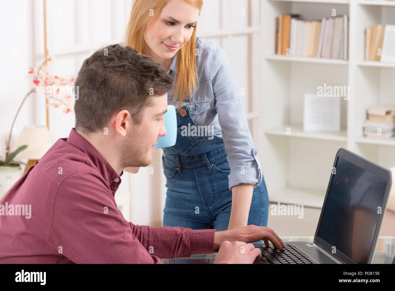 Happy couple looking at laptop computer screen Stock Photo - Alamy