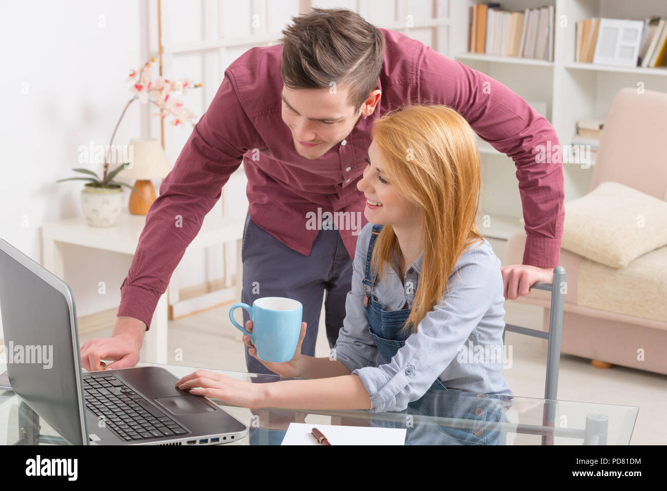 Happy couple looking at laptop computer screen Stock Photo - Alamy