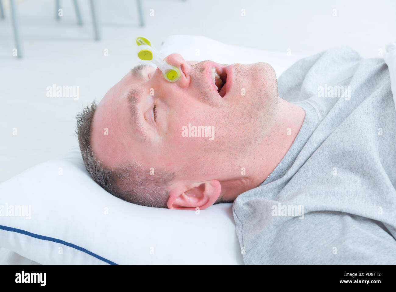 Snoring man in bed with cloth clip on his nose Stock Photo - Alamy