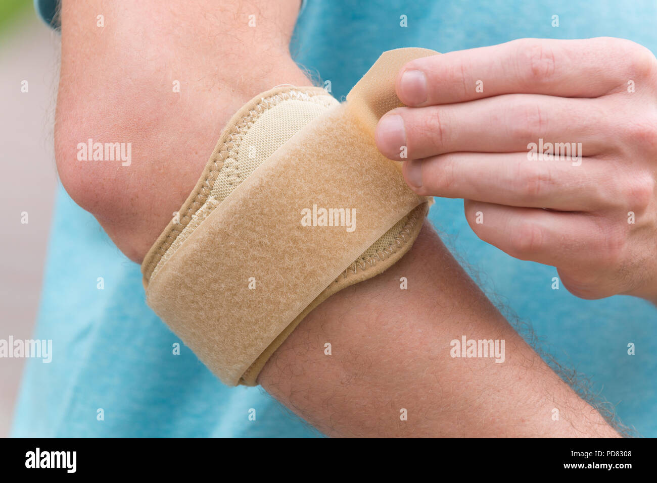 Man wearing elbow brace to reduce pain Stock Photo - Alamy