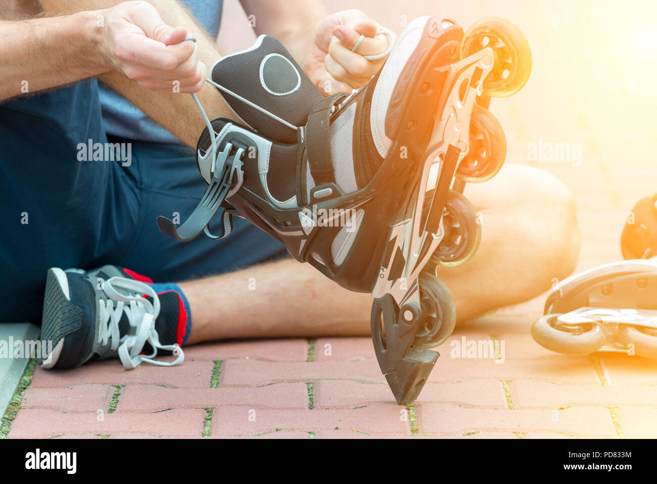 Man preparing for roller blading, putting on rollerblades Stock Photo ...