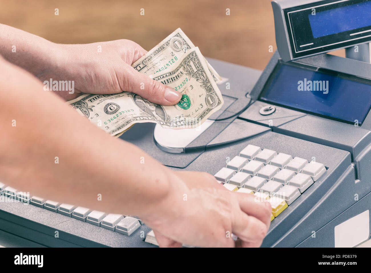 Cashier holdnig banknotes and using cash register at shop Stock Photo ...