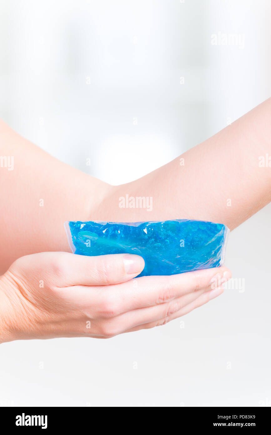 Using cold gel compress on elbow to reduce pain Stock Photo - Alamy
