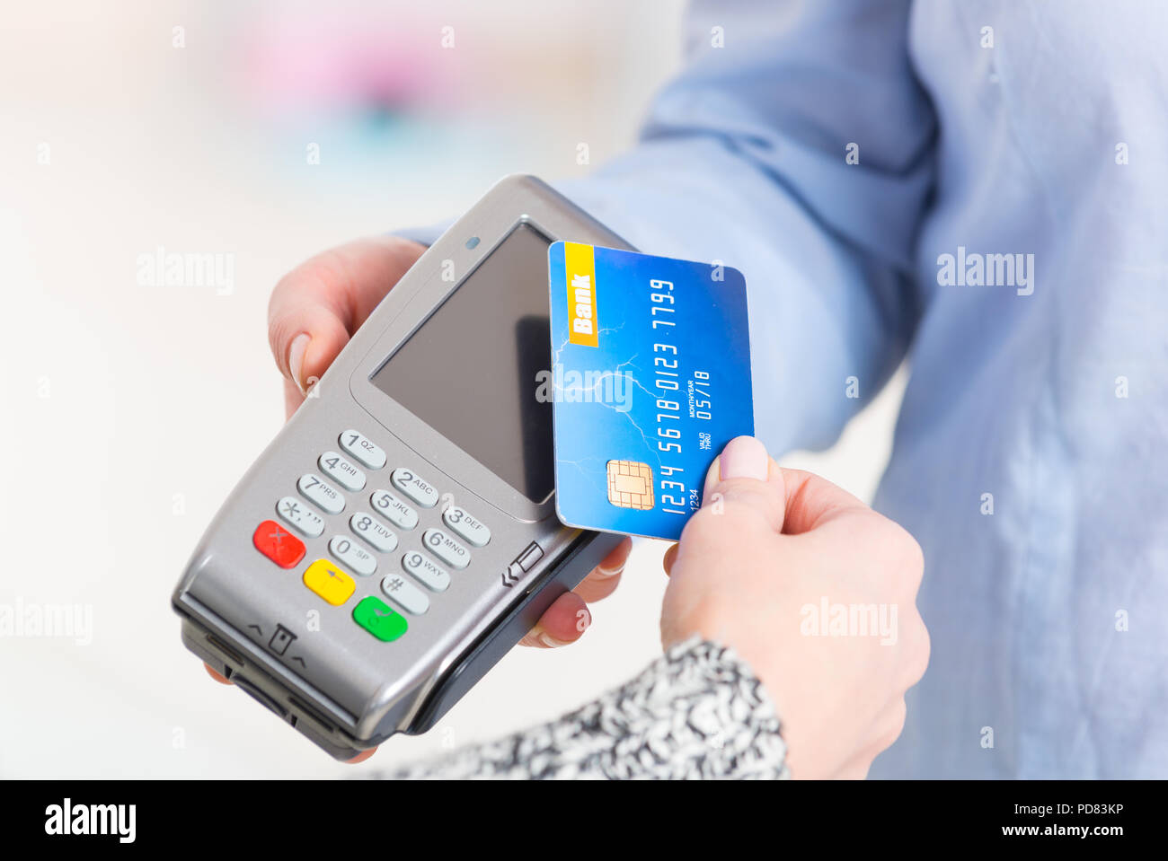 Hand holding contactless credit or debit card over wireless payment ...