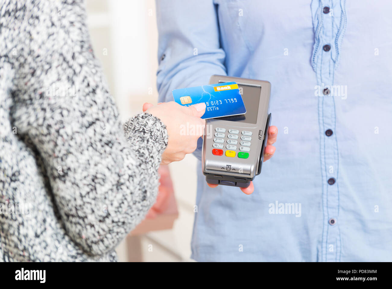 Hand holding contactless credit or debit card over wireless payment ...