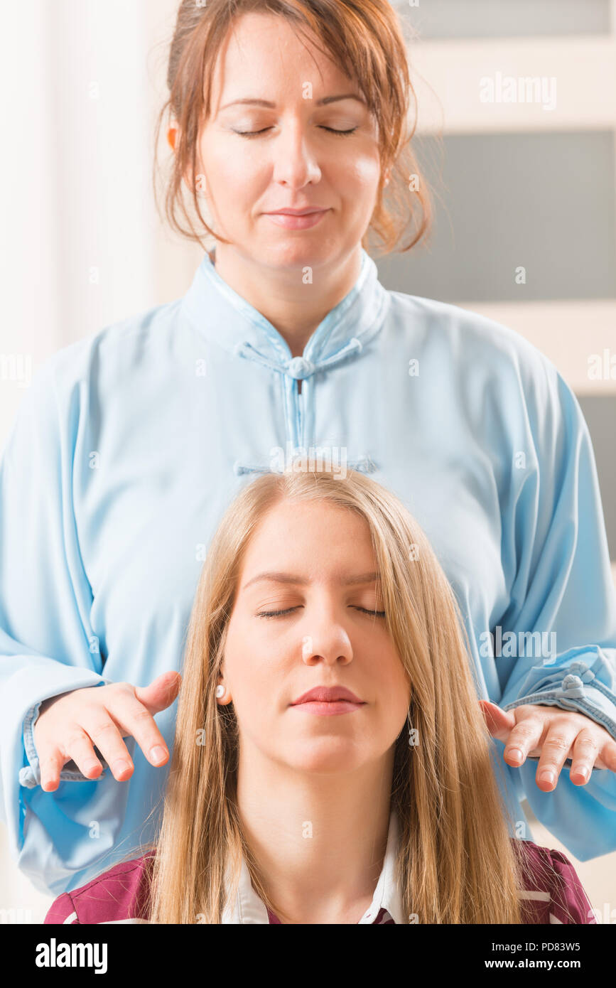 Professional Reiki healer doing reiki treatment to young woman Stock ...