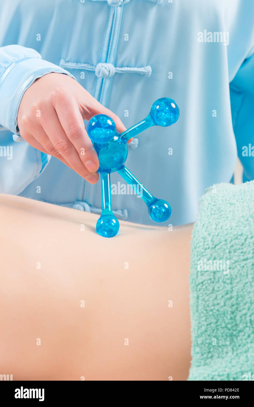 Therapist using massage tool on patient's back Stock Photo - Alamy