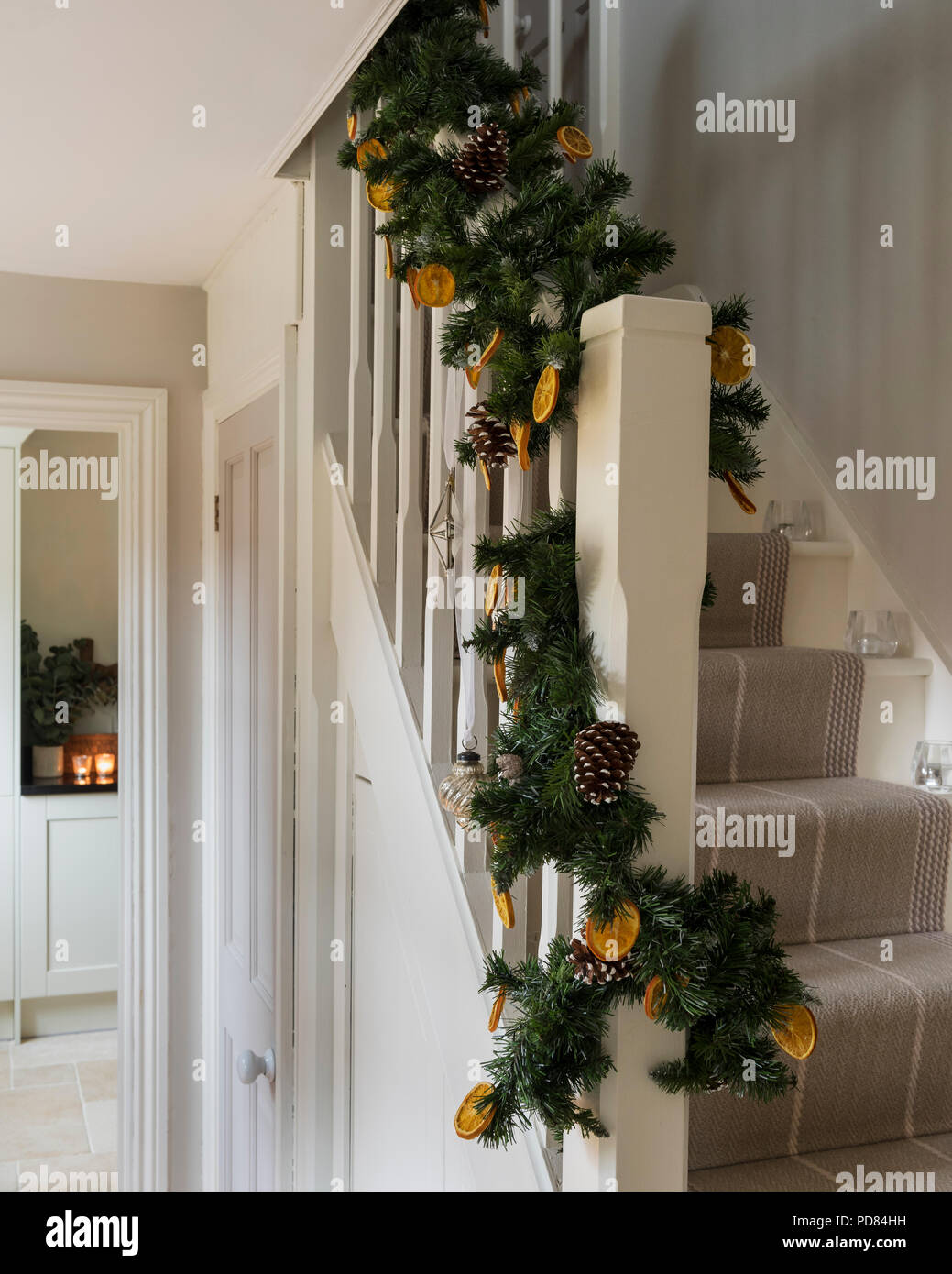 Decorative festive greenery winding up staircase banister in entrance ...
