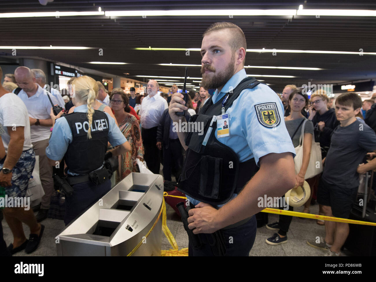 07.08.2018, Hesse, Frankfurt: Police officers and passengers are ...