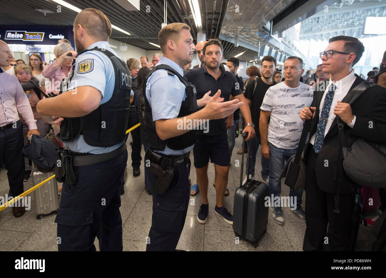 07.08.2018, Hesse, Frankfurt: Police officers and passengers are ...