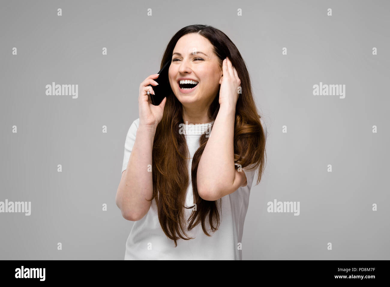 Emotional smiling happy plus size model standing in studio looking in ...