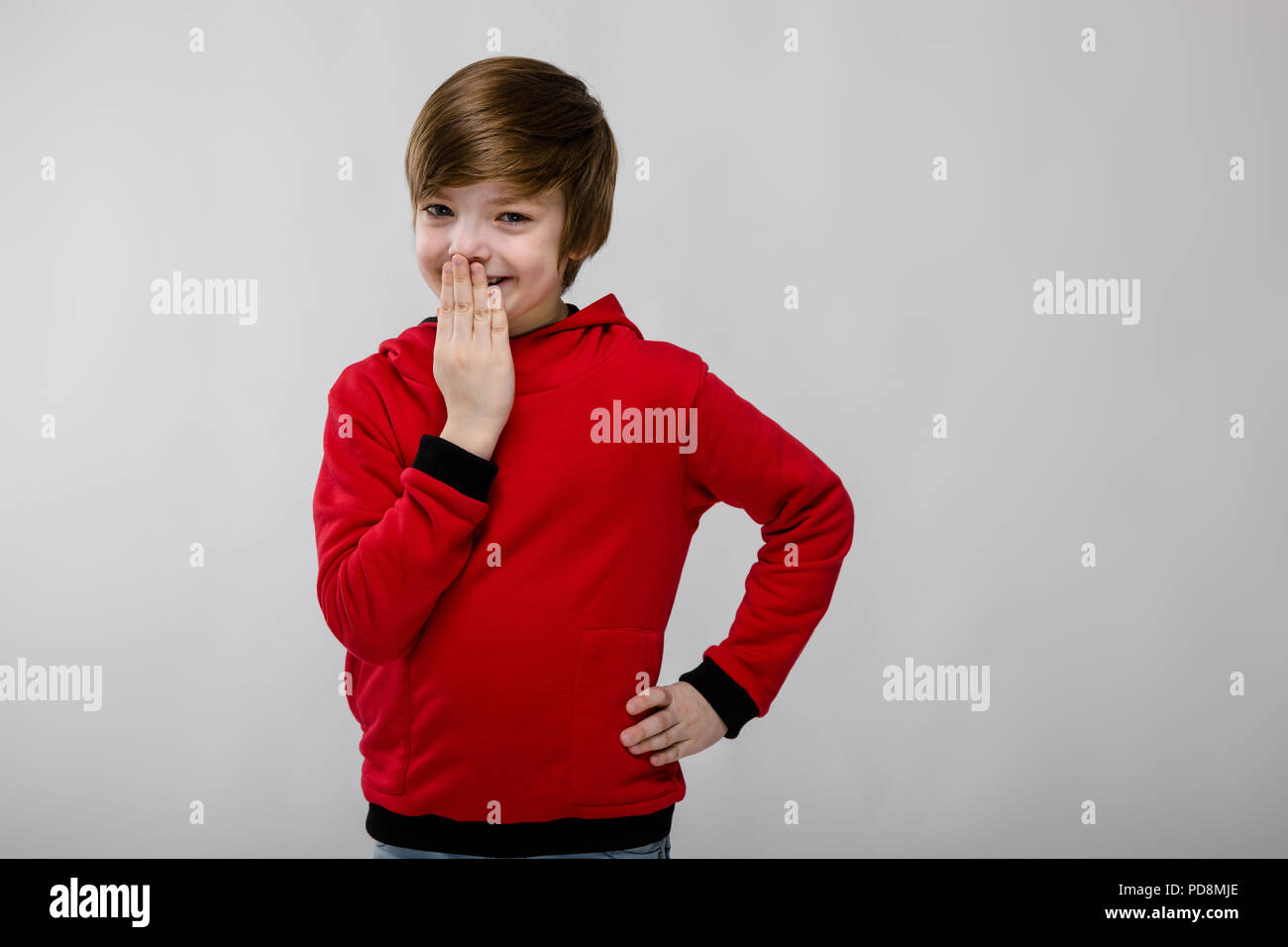 Cute curious cunning little caucasian boy in red sweater close his ...