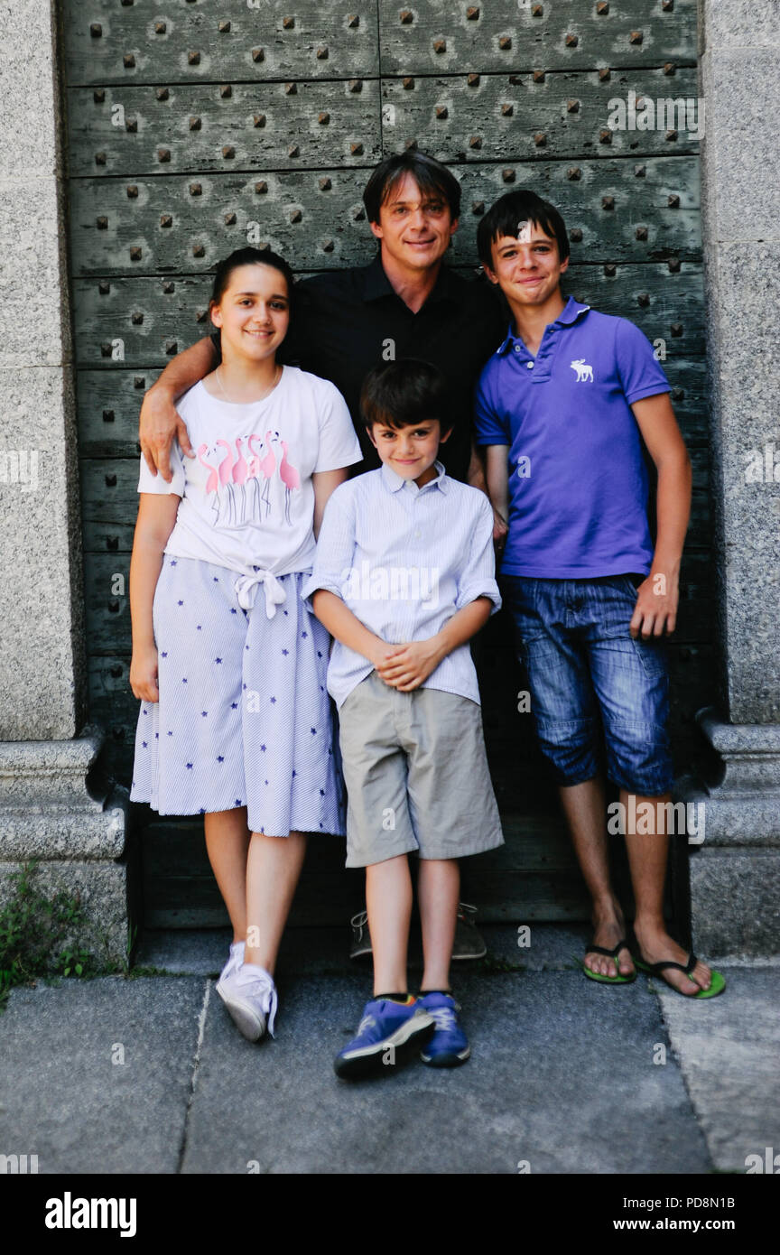 Father with his three sons poses in front of an old ancient monument ...