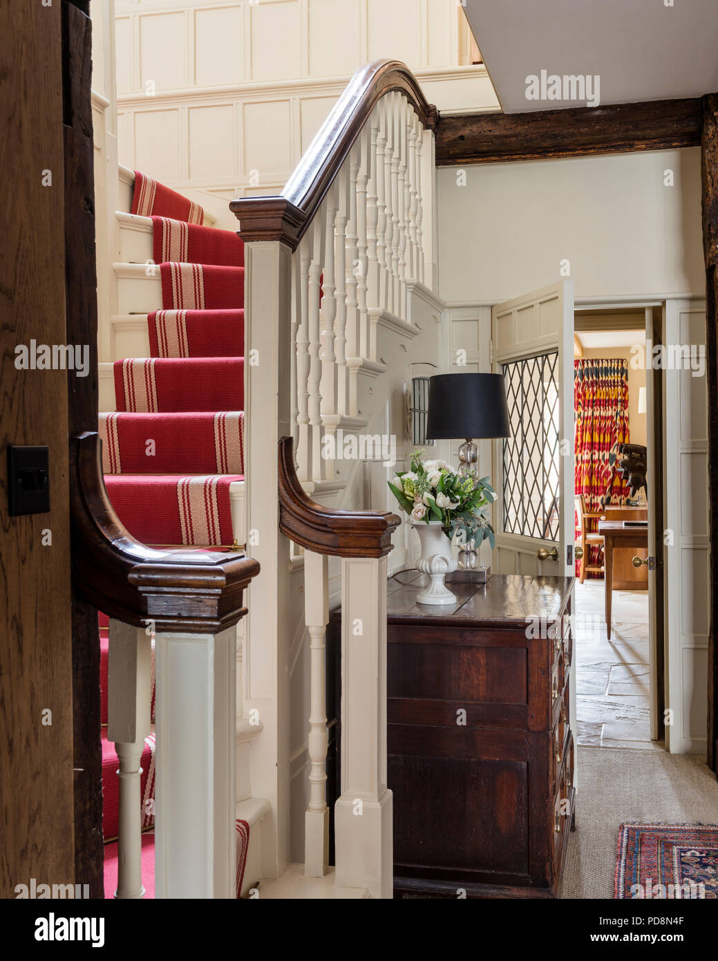 Wood panelled entrance hall with red carpet runner, 18th century oak ...