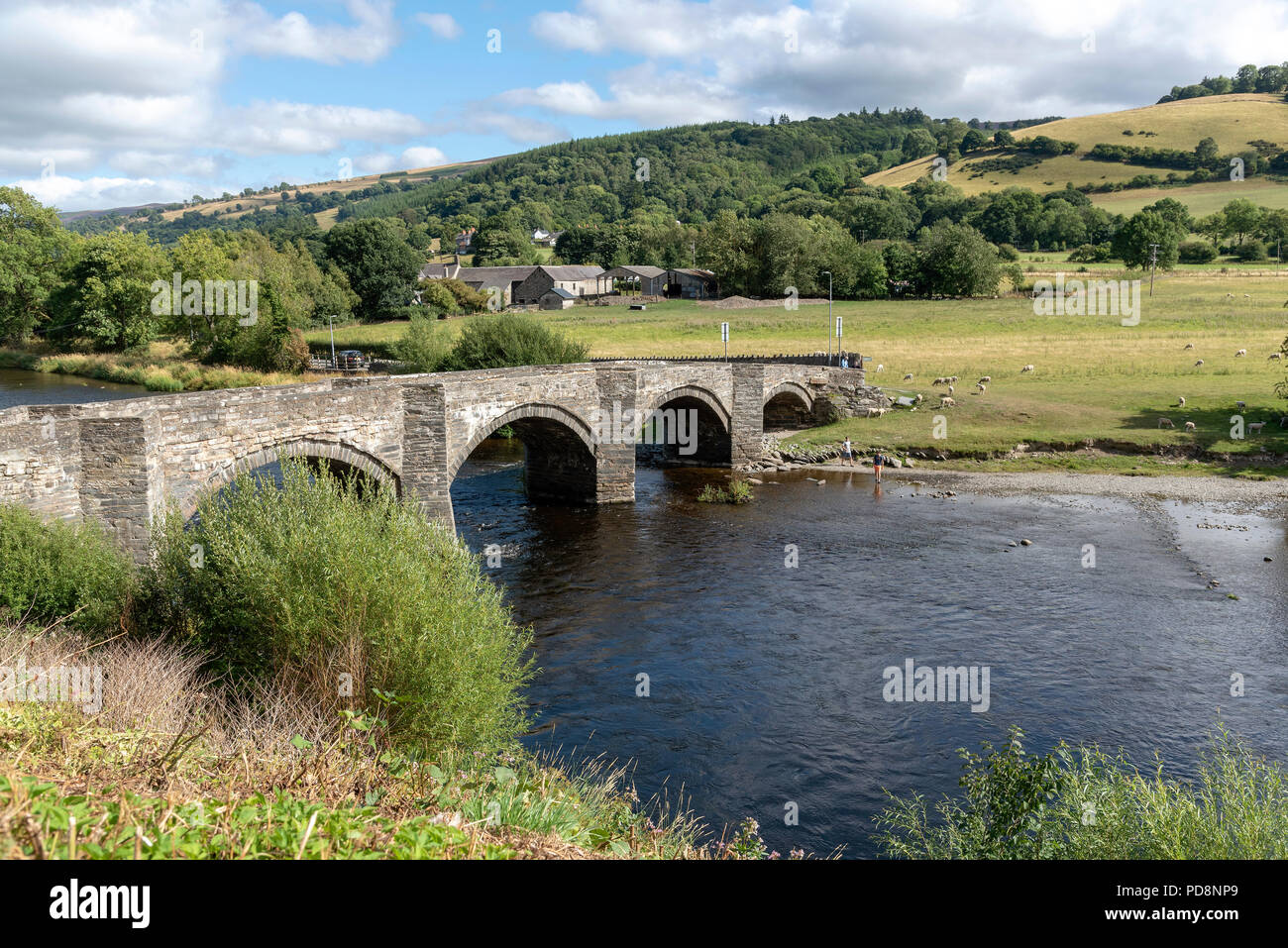 An old stone arched bridge over The River Dee flowing through the Vale ...