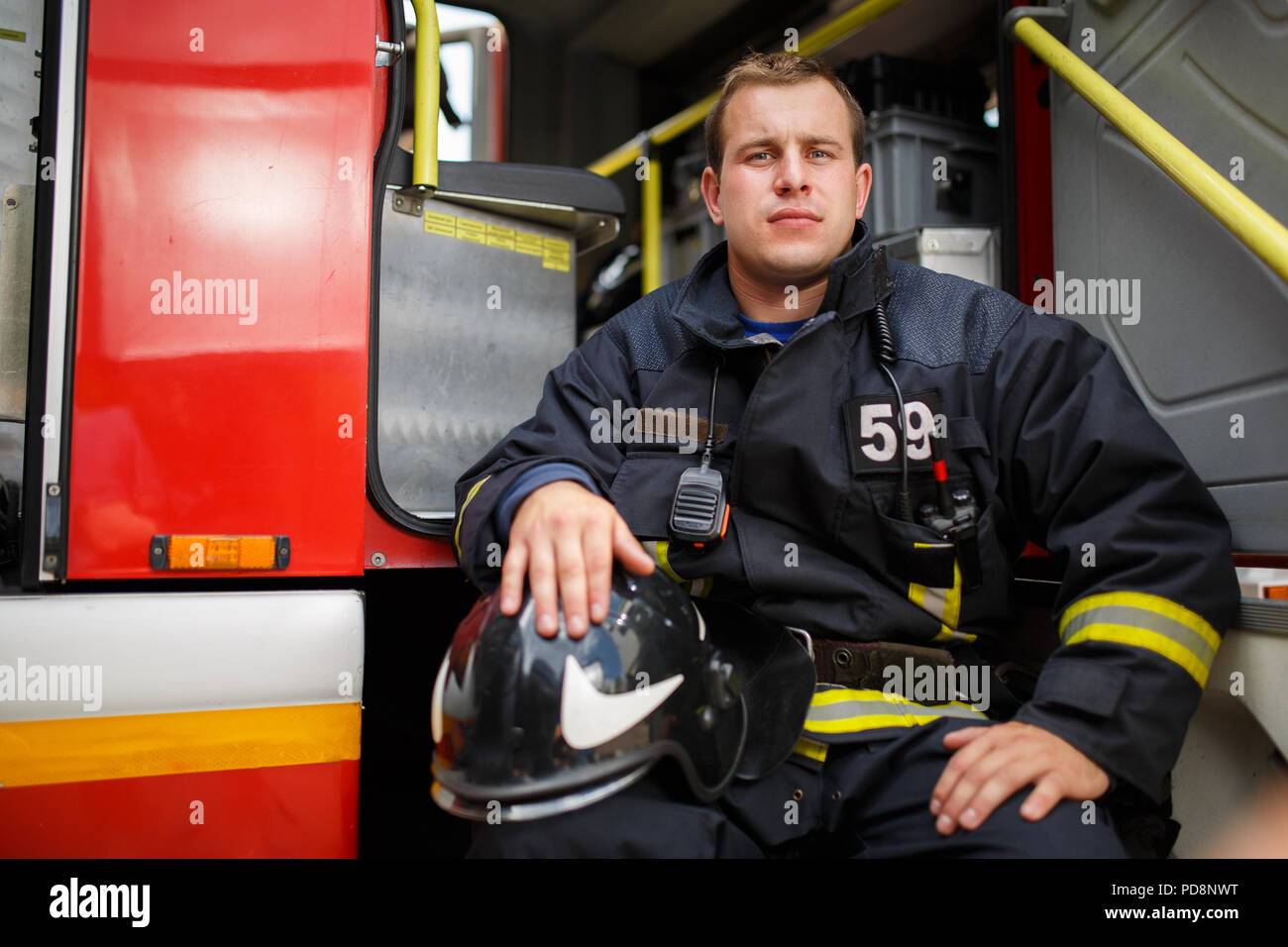 Photo of fireman sitting in fire truck Stock Photo - Alamy
