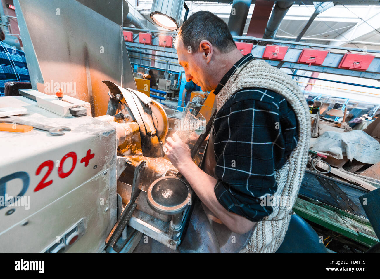 Glass production worker working with industry equipment on factory ...