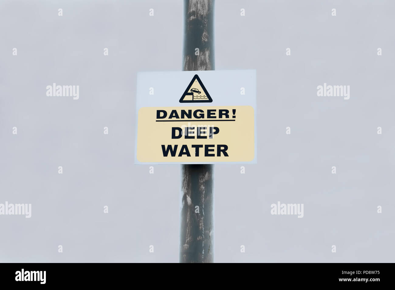 Danger deep water sign on post against sky background at sea harbour ...