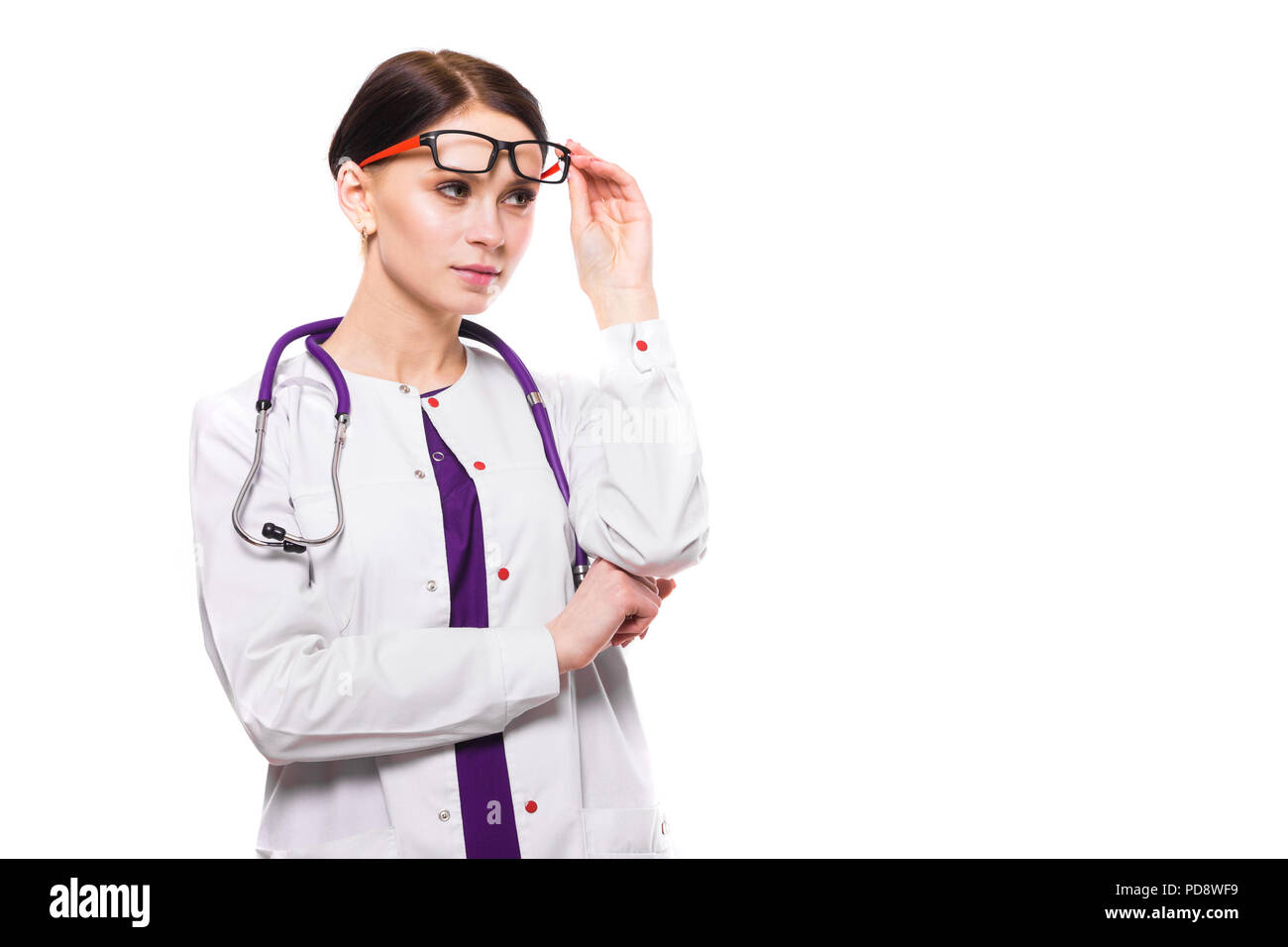 Young beautiful female doctor with raised glasses on white background ...