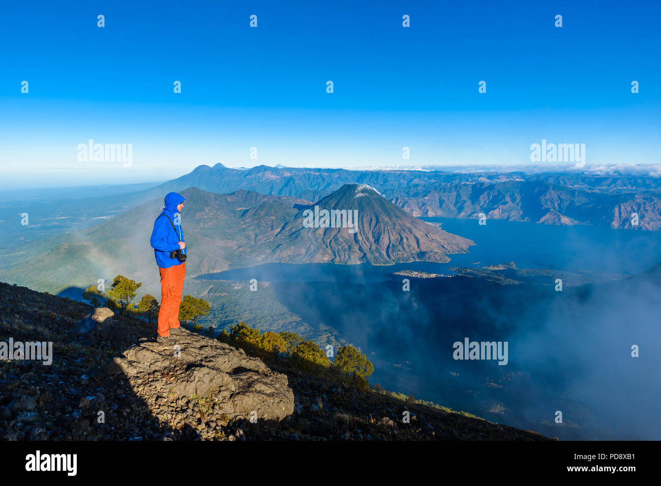 Hiker with panorama view of Lake Atitlan and volcano San Pedro and ...