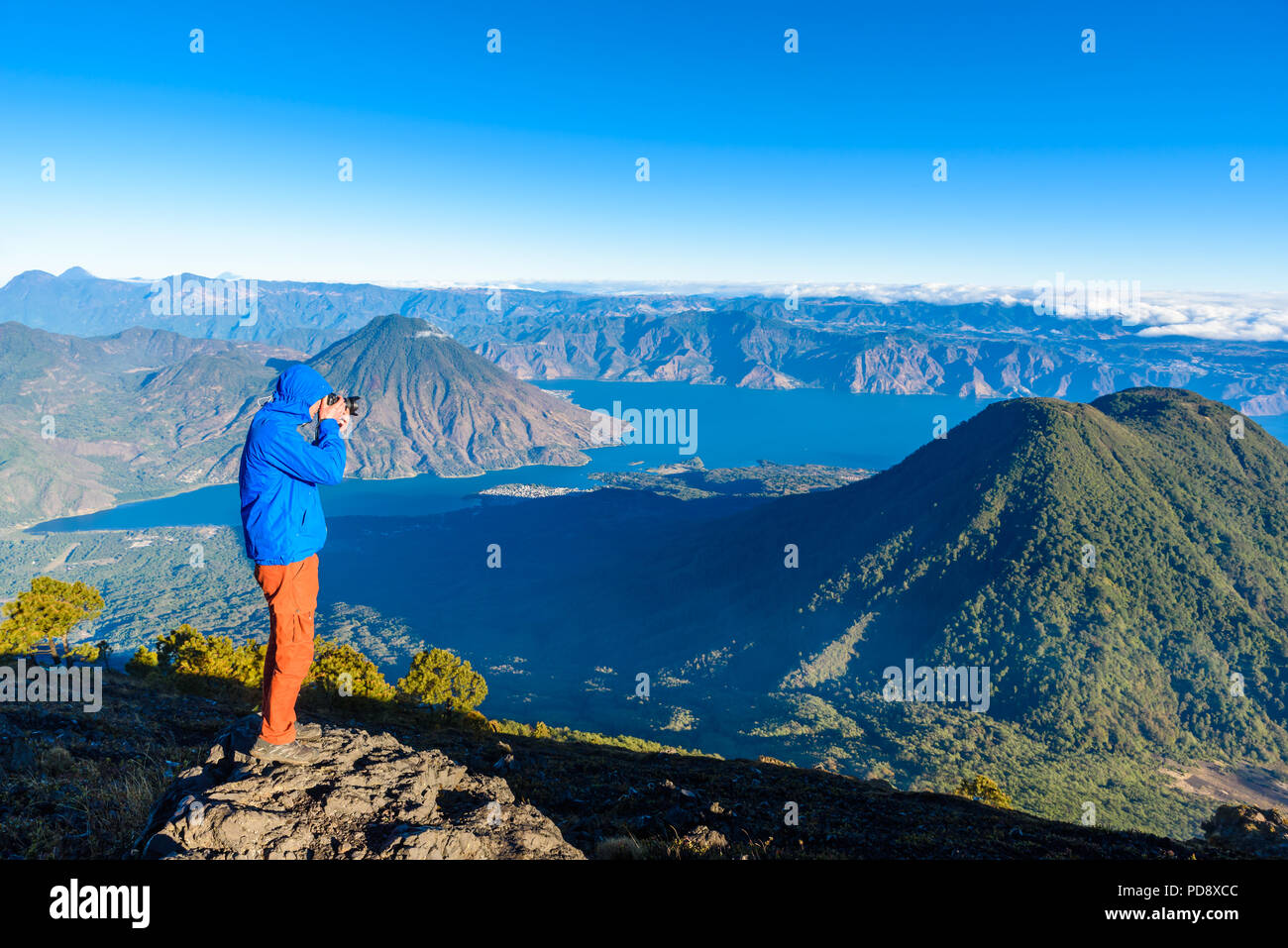 Hiker with panorama view of Lake Atitlan and volcano San Pedro and ...