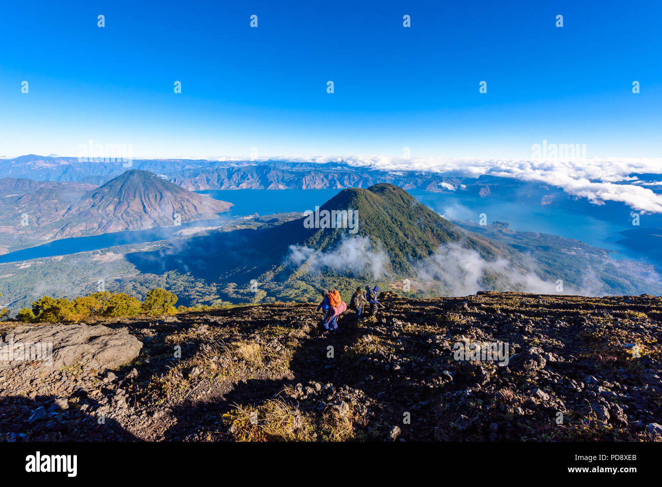 Hiker with panorama view of Lake Atitlan and volcano San Pedro and ...