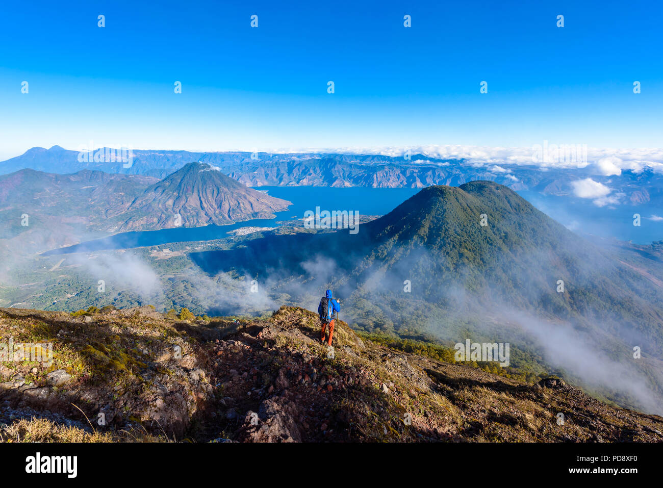 Hiker with panorama view of Lake Atitlan and volcano San Pedro and ...