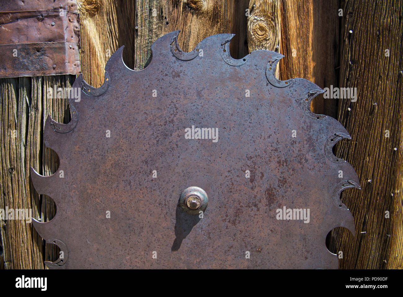 Rusted saw blade against a rustic weathered wood background at an ...