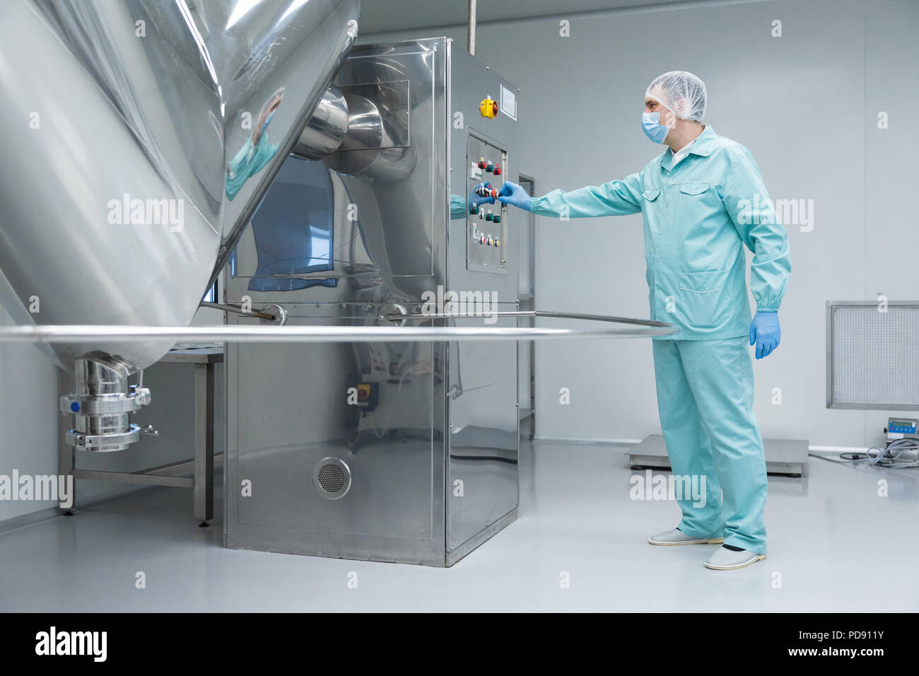 Pharmaceutical factory man worker in protective clothing working with ...