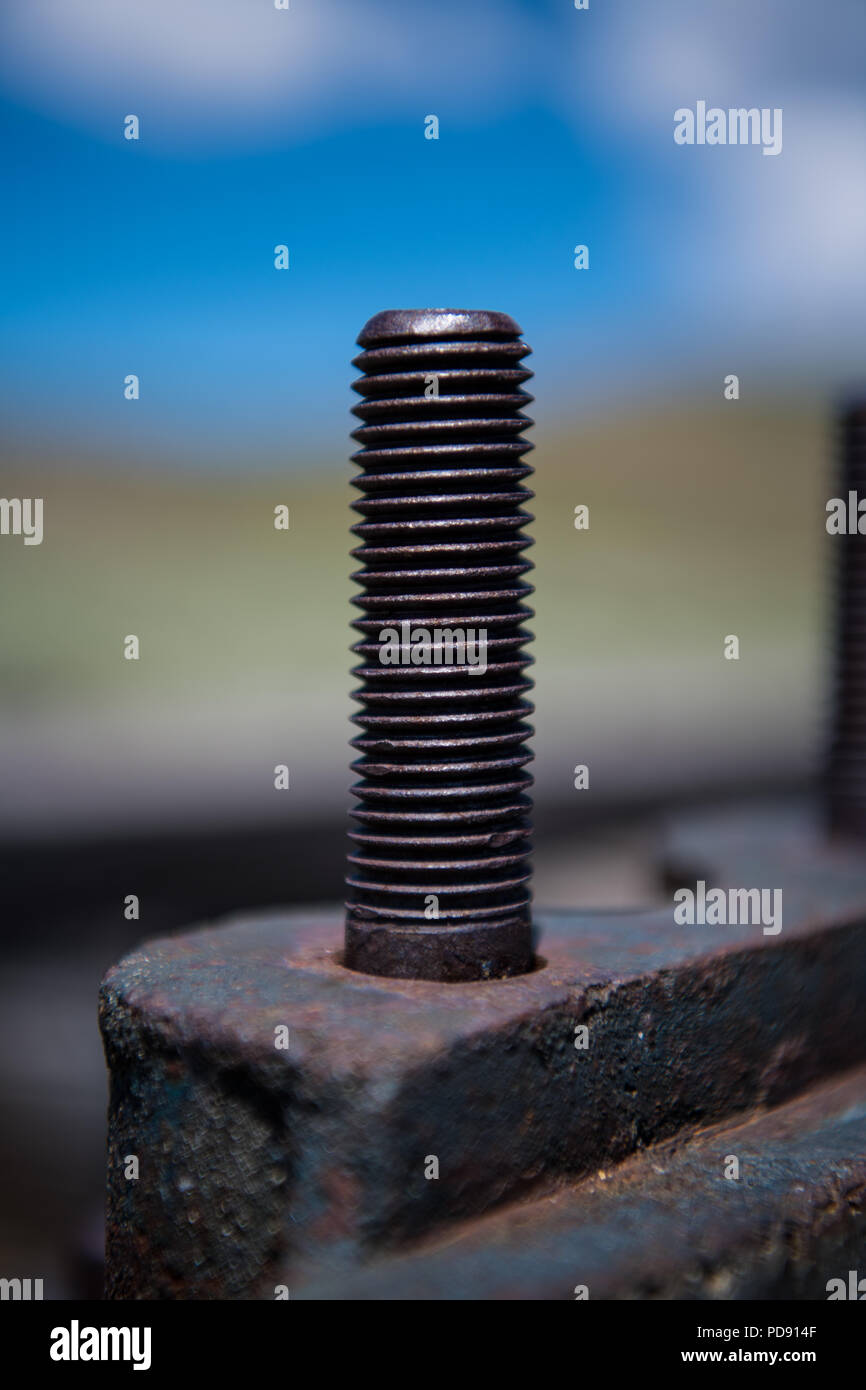 Close-up view of a rusted iron bolt against a blurred background of ...