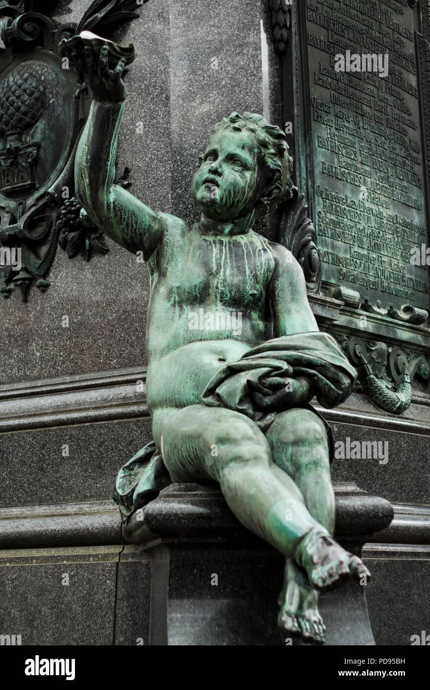 Green copper angel statue praying with a hand towards the sky in ...