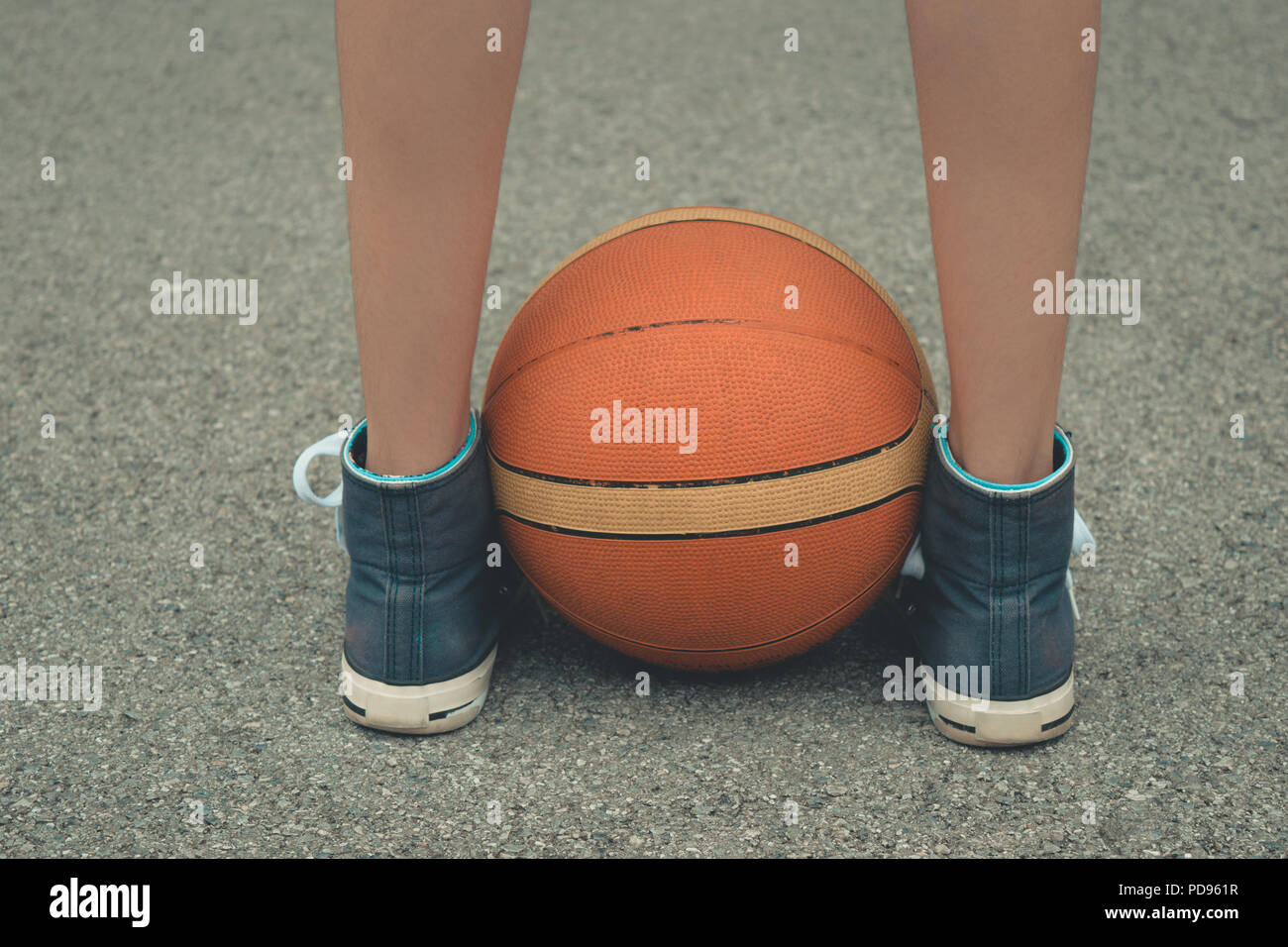 Young girl legs wearing sneakers standing directly above the ball on ...