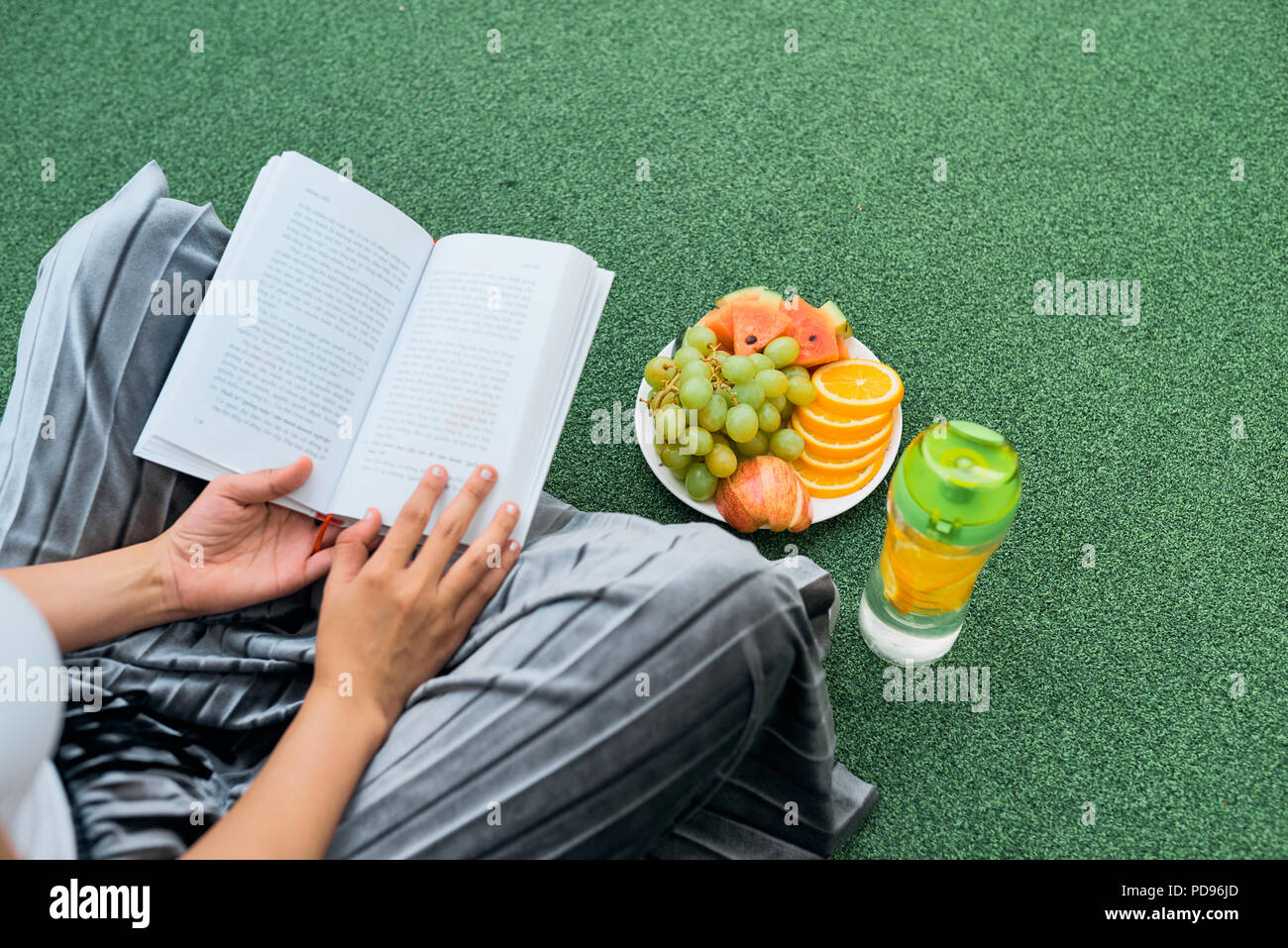 woman reading book on the lawn, top view over shoulder Stock Photo - Alamy