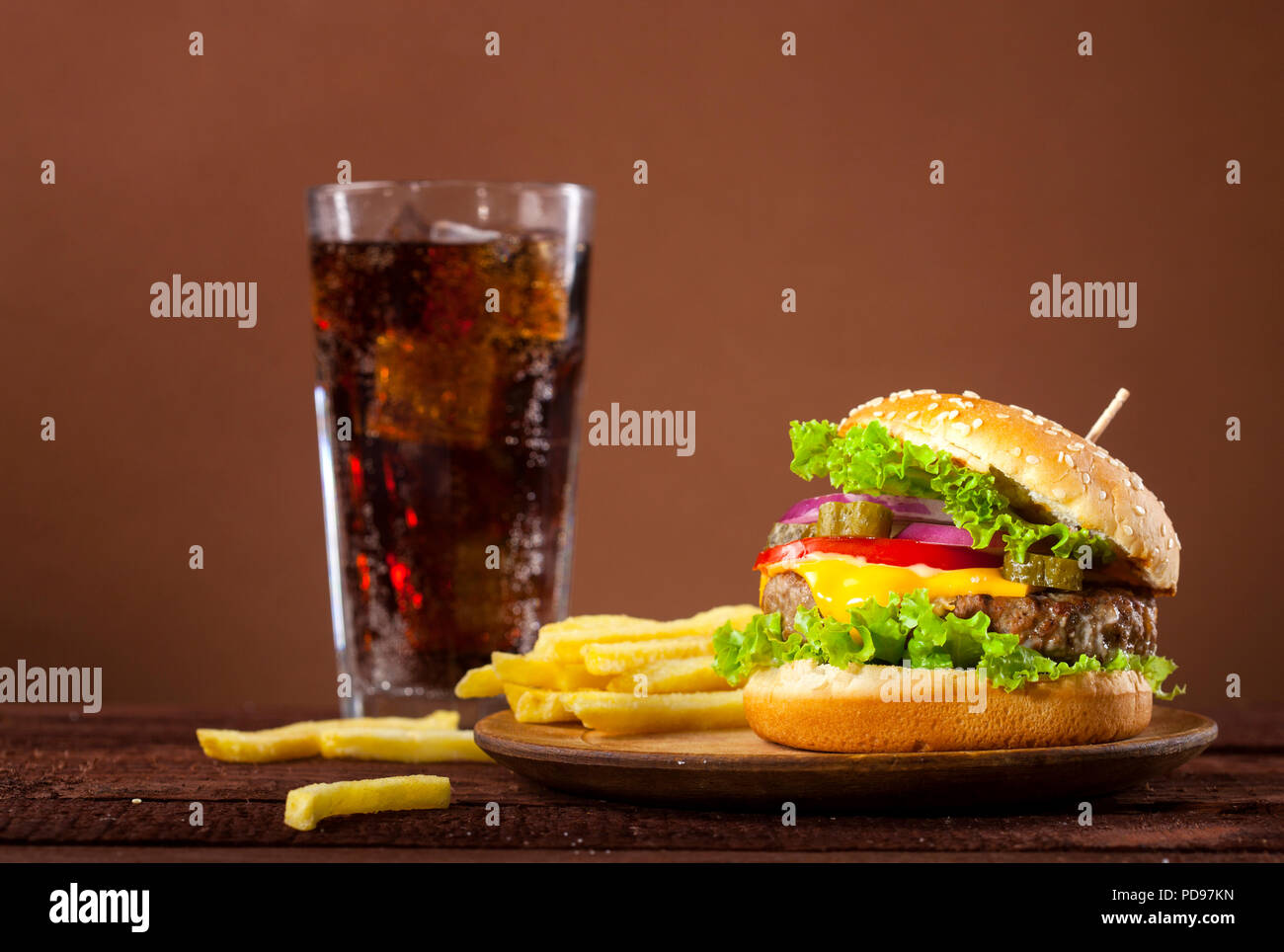 Two different delicious big burgers and glass of on wooden table and ...
